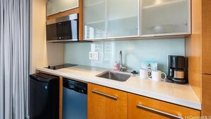 Cozinha compacta com lava-louças, cafeteira e micro-ondas.