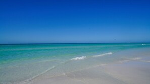Uma praia com águas turquesa cristalinas e areia branca.