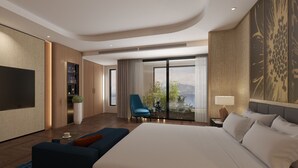 Quarto de hotel moderno com uma cama grande, área de estar com um sofá azul, uma poltrona e uma TV.