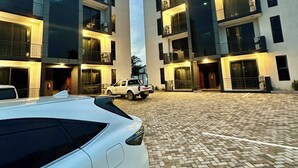 Um edifício moderno com várias varandas e um pátio pavimentado.