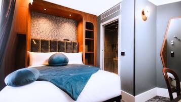 Quarto com cama, cabeceira de madeira, guarda-roupa e uma cadeira.