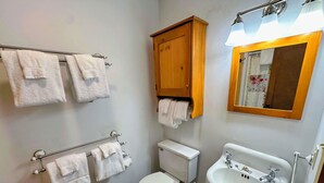 Uma casa de banho com sanita, lavatório e armário de madeira.