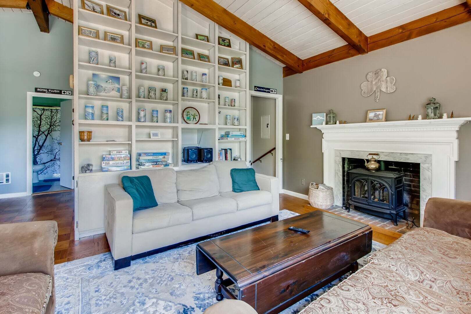 Uma sala de estar com sofá branco, mesa de centro e lareira.