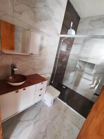 Chuveiro, toalhas de banho, papel higiênico 