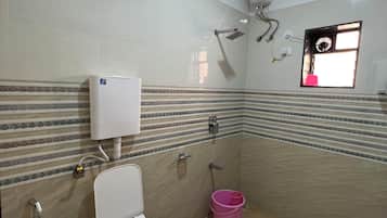 Quarto Deluxe | Casa de banho | Um polibã, toalhas fornecidas, sabão, papel higiénico