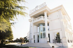 Um edifício branco com varanda e uma placa que diz 'ROYAL HILL'.