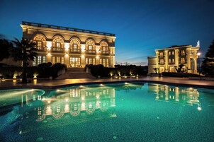 Um edifício grande e elegante com uma piscina que reflete sua arquitetura.