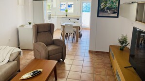 Uma sala de estar moderna com um sofá, uma mesa de centro de madeira e um suporte para televisão.