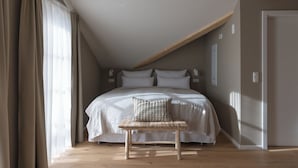 Quarto com uma cama grande, um banco e uma luminária no teto.