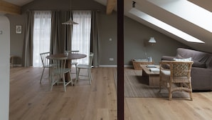 Um loft espaçoso com área de jantar, sofá e cadeira de vime.