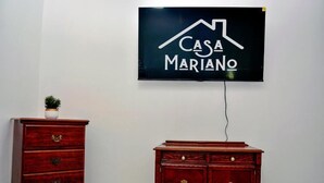Quarto com televisão na parede exibindo 