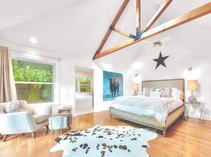 Quarto com uma cama grande, decoração em forma de estrela e tapete de couro de vaca.
