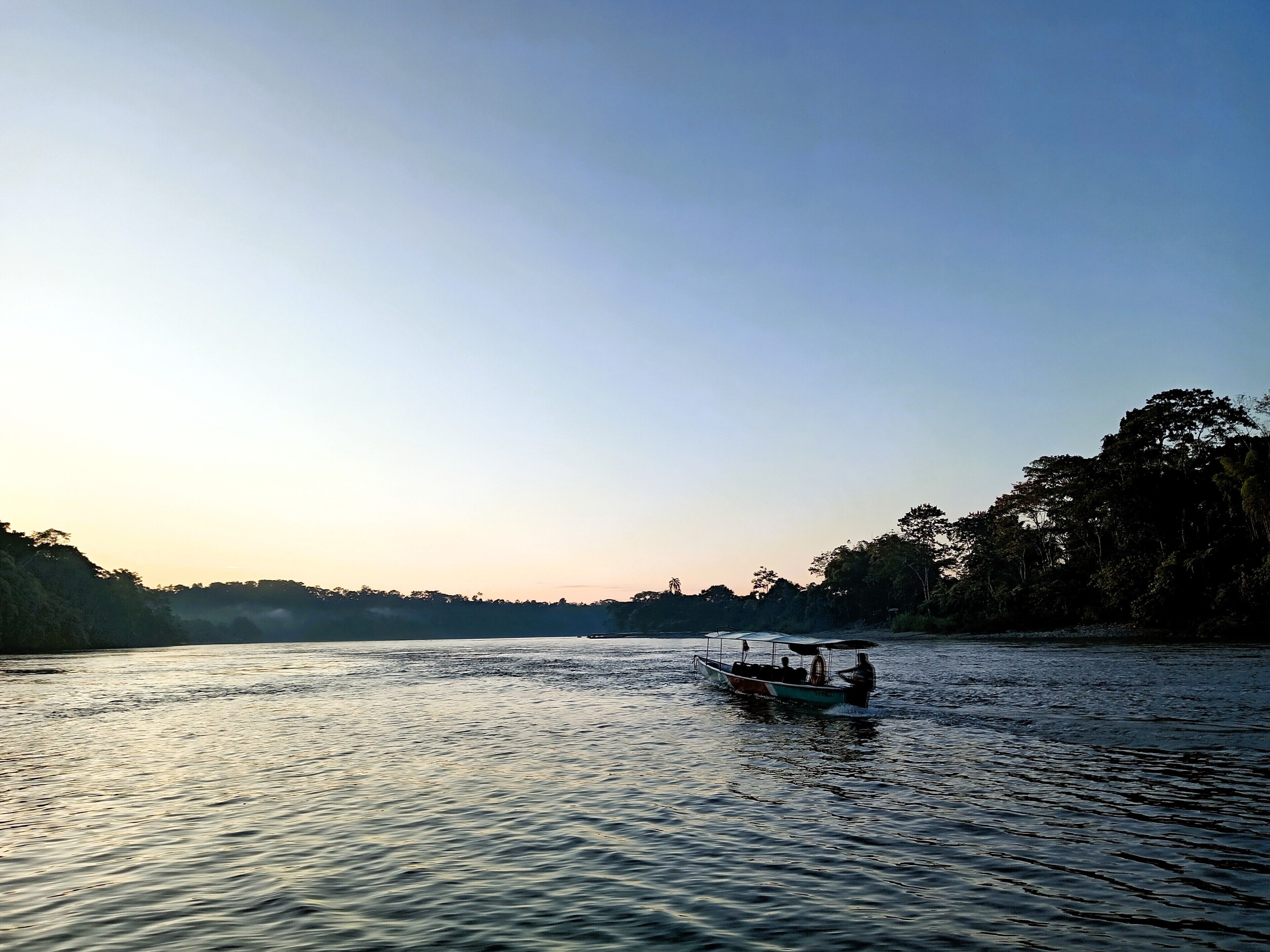Um rio calmo com um barco transportando passageiros.