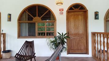 Uma porta de madeira com um painel de vidro, um banco e um lustre.