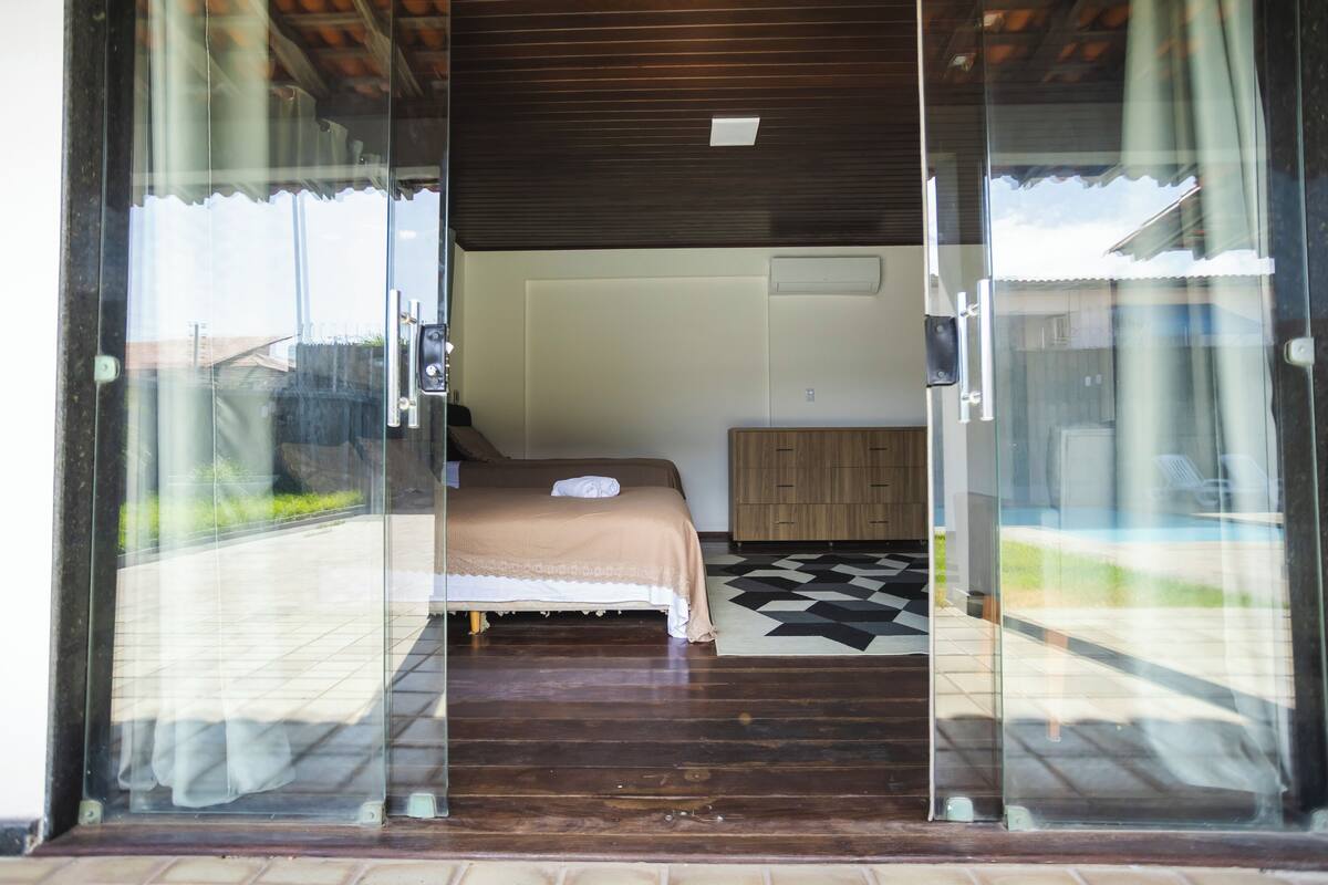Um quarto com uma cama, um guarda-roupa de madeira e um chão xadrez.