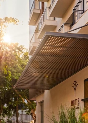 Um edifício moderno com telhado plano, logotipo visível e varanda.