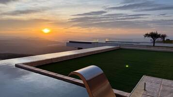 Terraço moderno no telhado com vista para o pôr do sol sobre um vale.