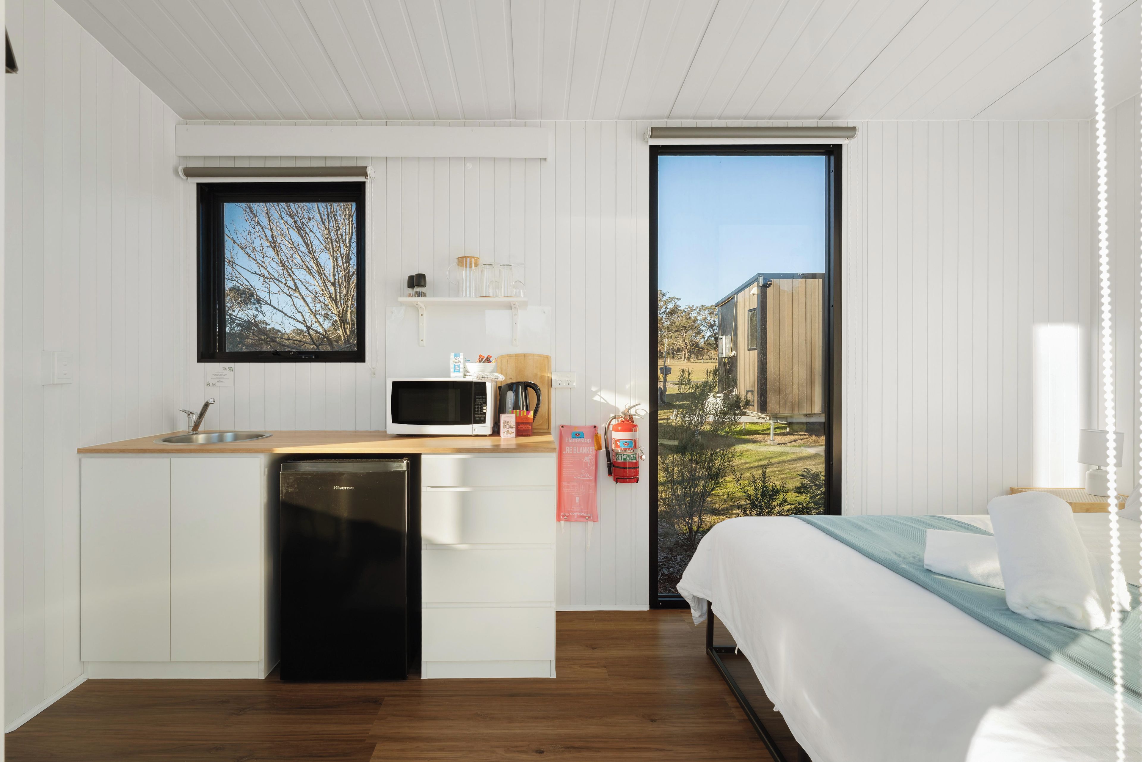 Quarto compacto com cama e vista para o exterior.
