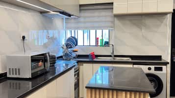 Um frigorífico, um micro-ondas, um forno, utensílios de cozinha