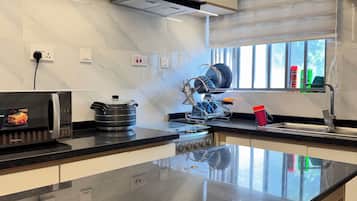 Um frigorífico, um micro-ondas, um forno, utensílios de cozinha