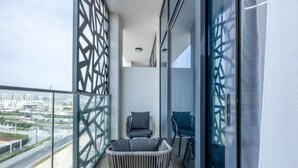 Varanda com vista para a cidade, uma cadeira e uma mesa.
