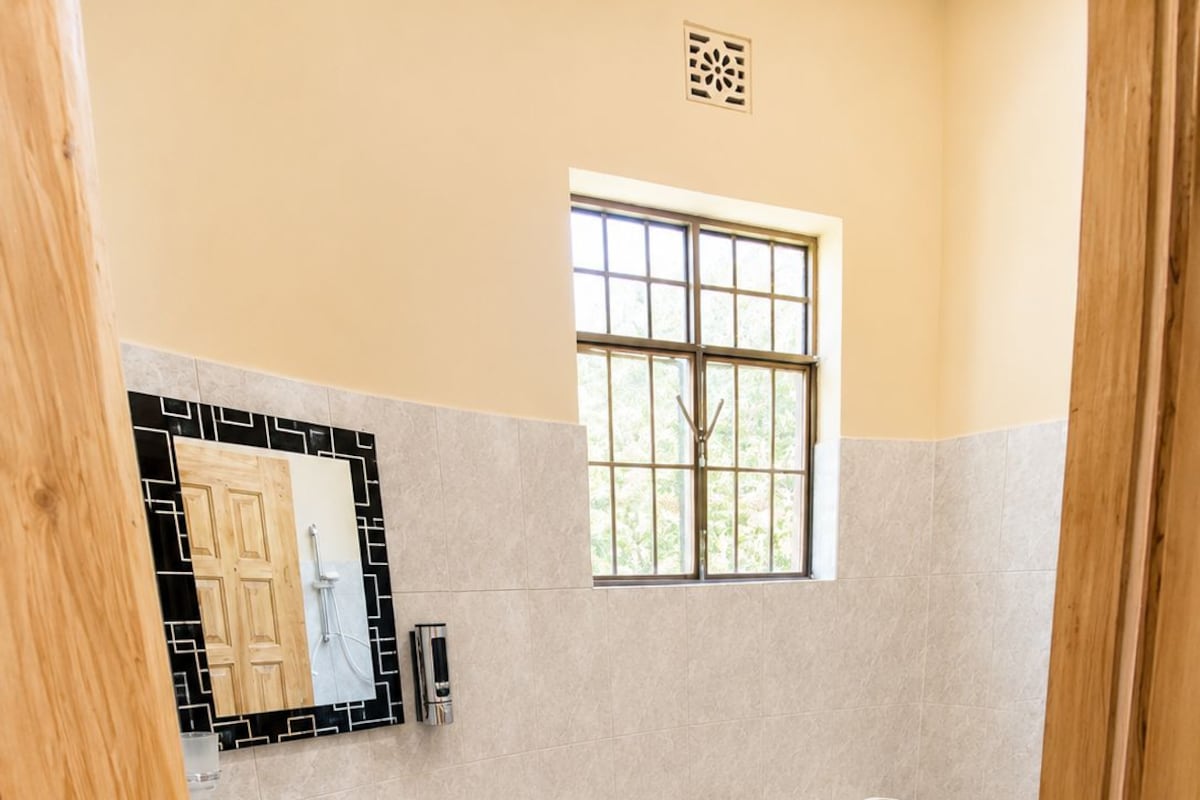 Casa de banho com lavatório, sanita e janela.