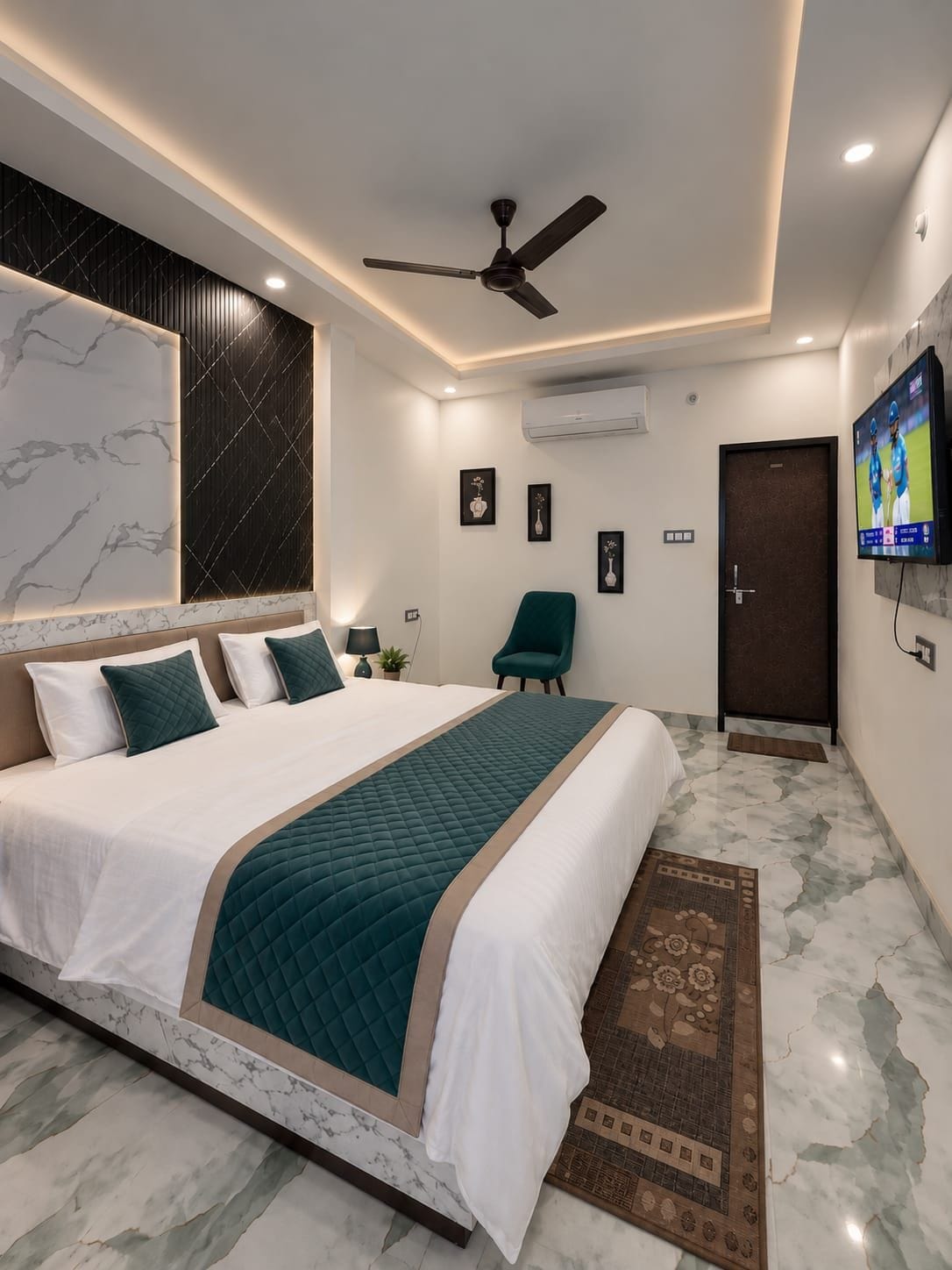 Quarto moderno com cama grande, ventilador de teto, ar-condicionado, televisão e uma porta.