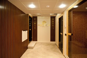 Um corredor com parede de painel de madeira, piso de azulejo e placa indicando spa.