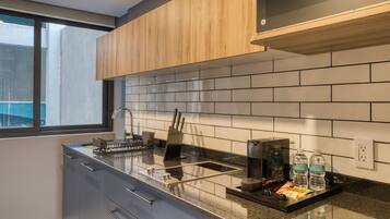 Uma cozinha moderna com bancada de granito, armários de madeira e painel de fundo preto.