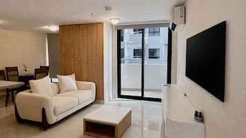 Apartamento Signature, não fumadores, Vista para a cidade | Sala de estar | Smart TV de 55 polegadas com canais digitais, Netflix