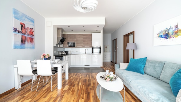 Um apartamento moderno com área de jantar, cozinha e sala de estar.