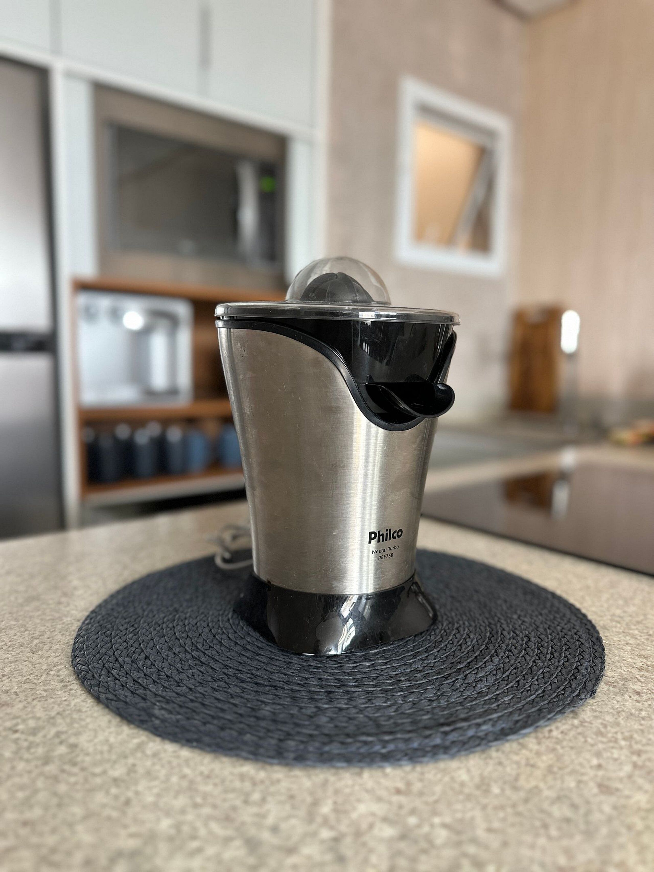 Uma cozinha com um centrífuga Philco Nectar Turbo PEF750 sobre um tapete preto.