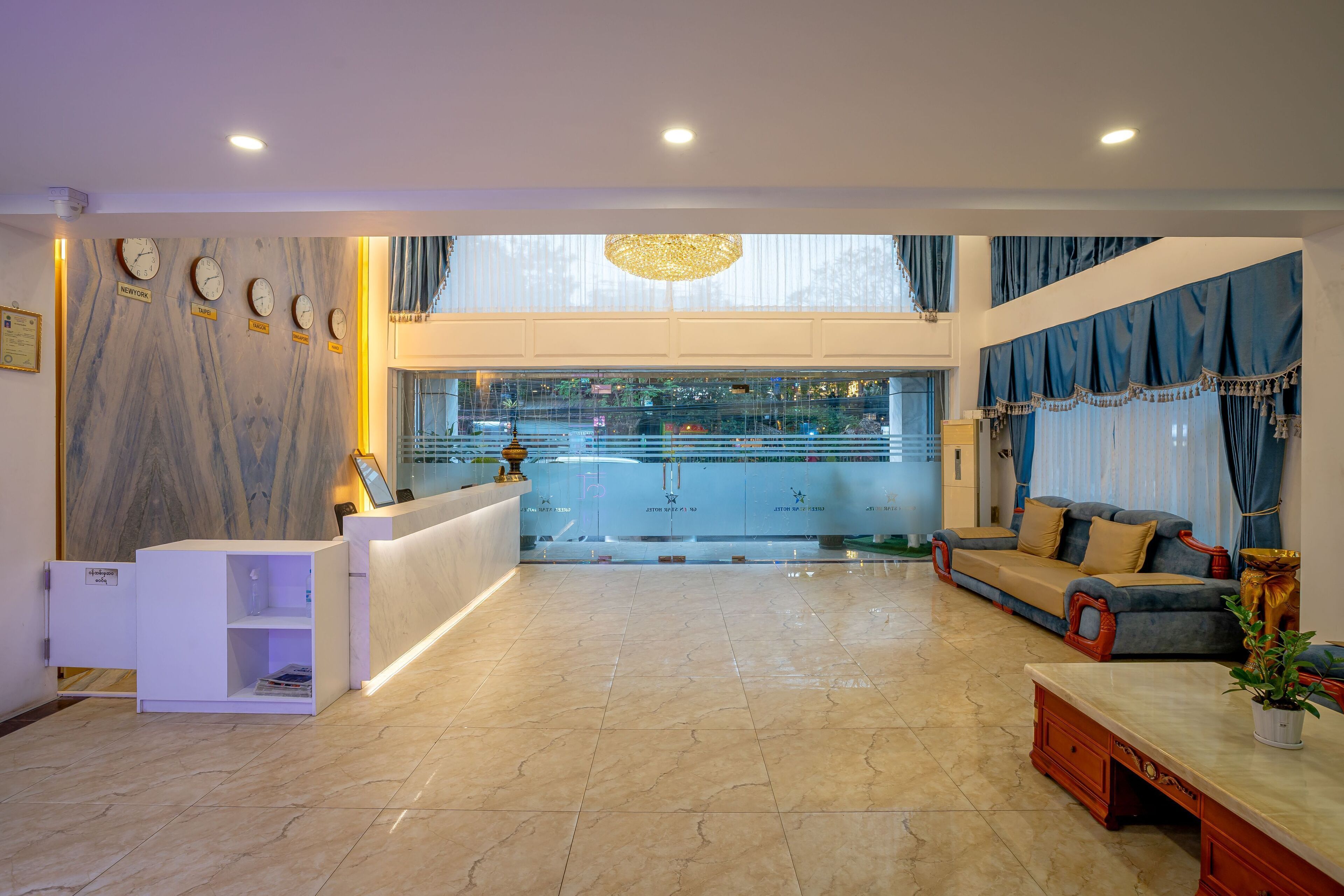 Um hall amplo com balcão de recepção, um sofá e área de refeições com vista para a cidade.