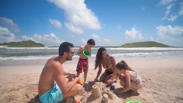 Na praia, espreguiçadeiras, guarda-sóis de praia, toalhas de praia