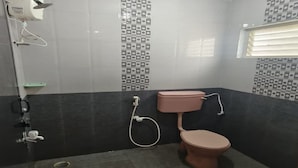 Casa de banho com sanita, chuveiro e janela.