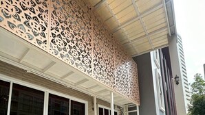 Um edifício moderno com fachada estampada, grandes portas de vidro e um espaço ao ar livre com piso de azulejos.