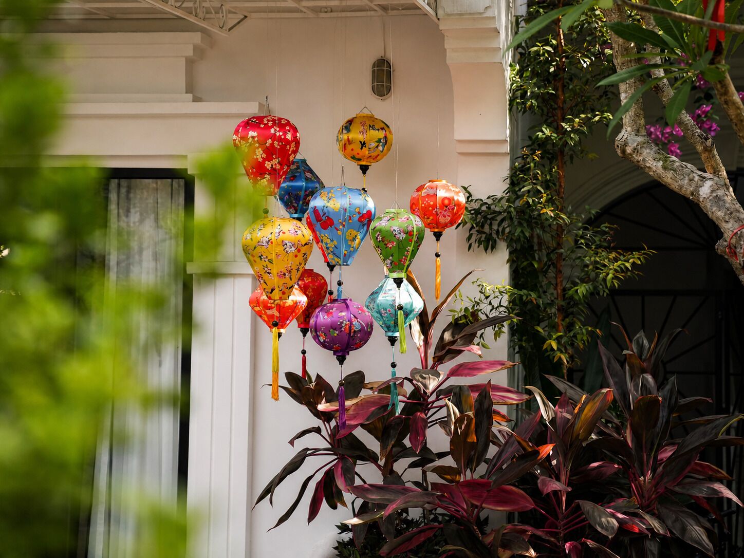 Fachada de edifício com lanternas coloridas penduradas.