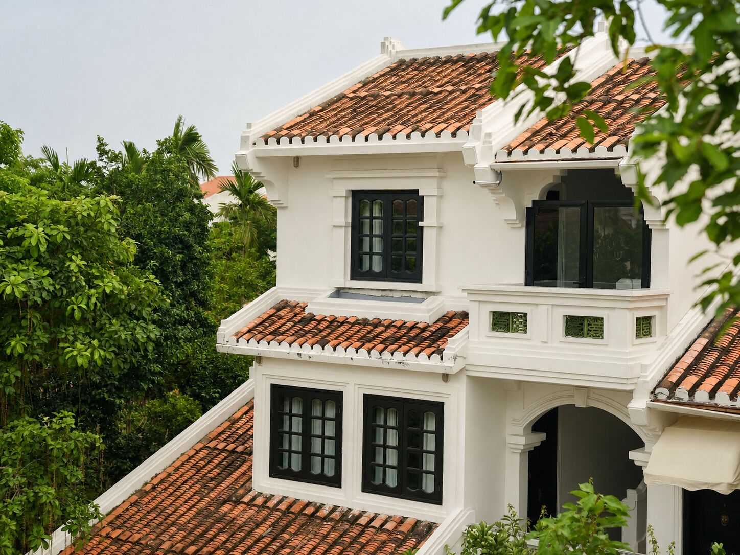 Um edifício de dois andares com telhado de azulejos e paredes brancas.