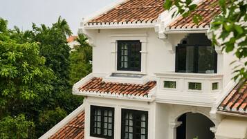 Um edifício de dois andares com telhado de azulejos e paredes brancas.