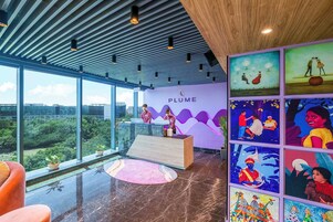 Uma área de recepção moderna com vista para a cidade, um balcão e obras de arte coloridas na parede.