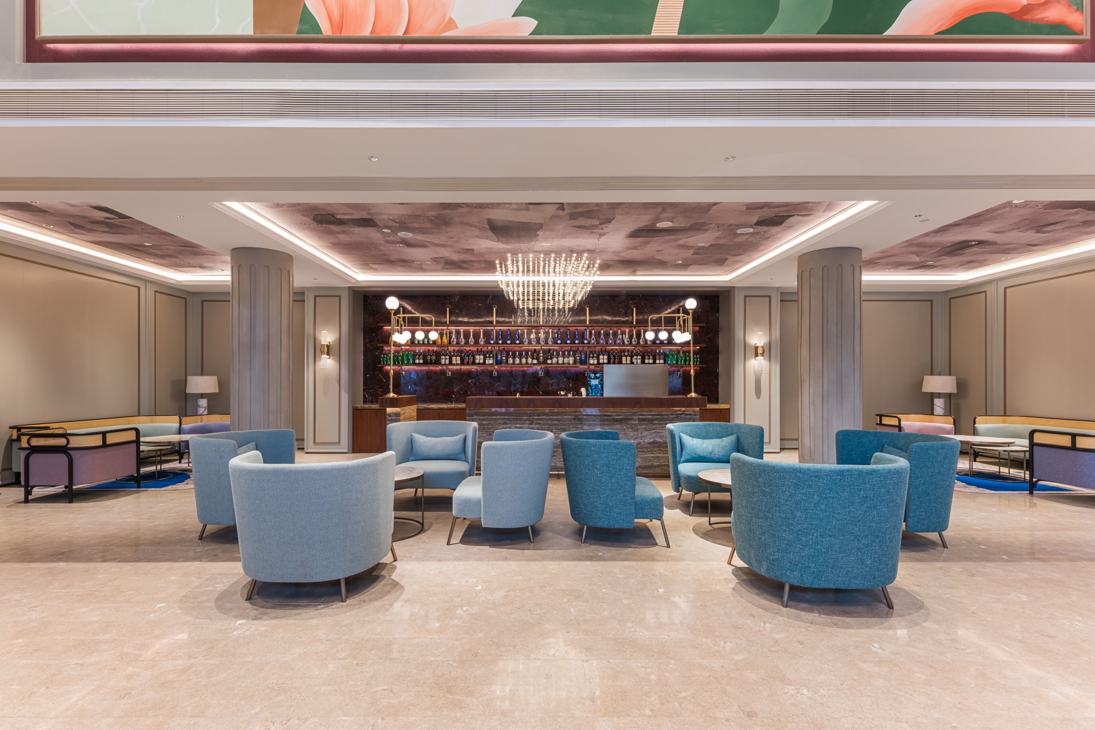 Um lobby com área de bar, assentos e um candelabro.