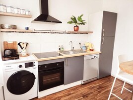 Uma cozinha compacta com máquina de lavar, forno, lava-louças e pia.