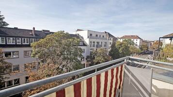 Uma área residencial com fileira de casas, cerca de metal e árvores.