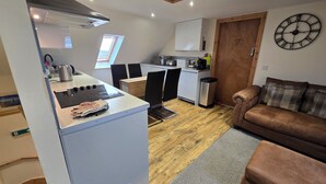 Um espaço compacto com cozinha compacta, área de refeições e sala de estar.