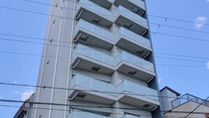 Um edifício com vários andares e design moderno, com varandas em cada pavimento.