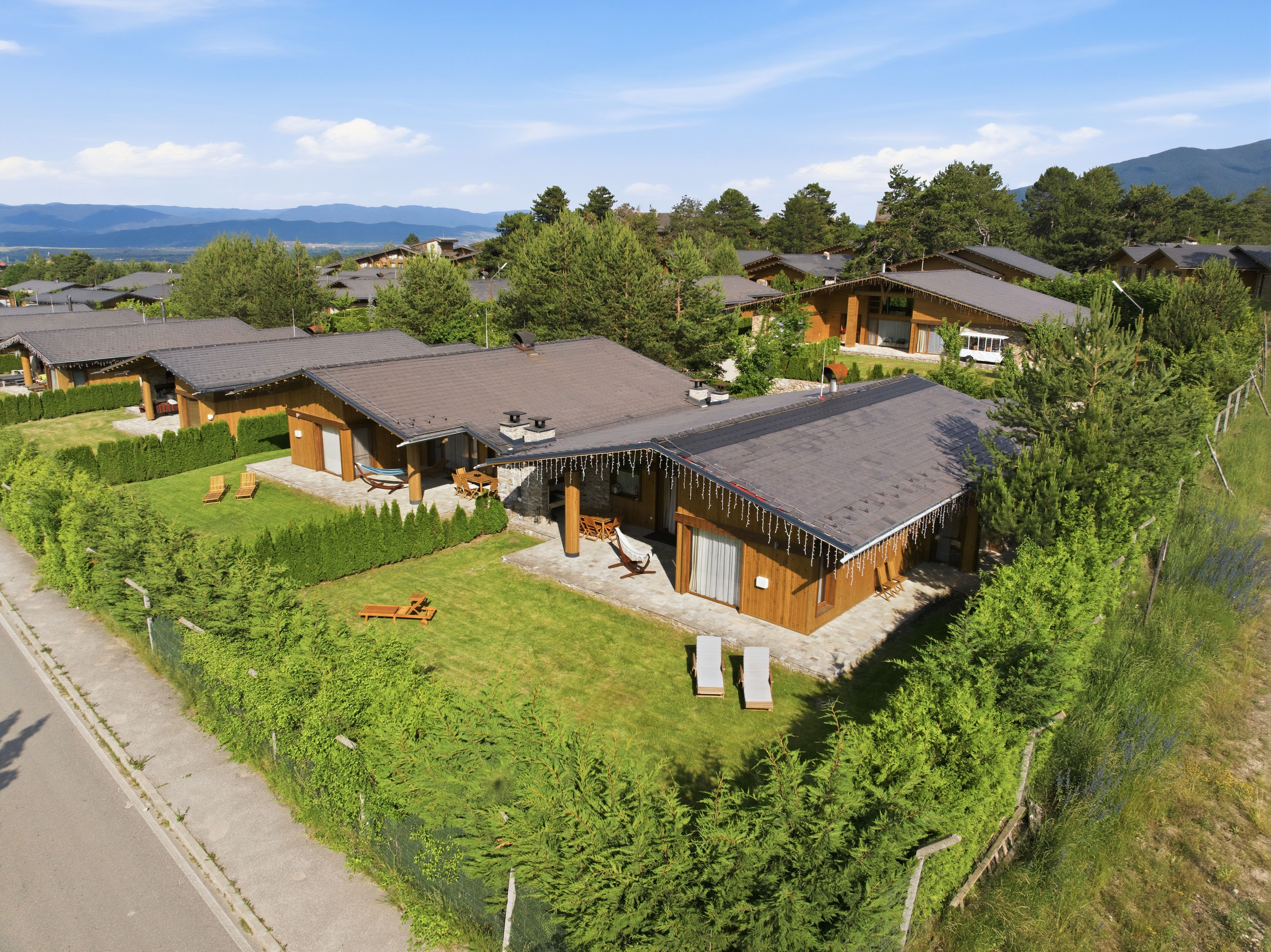 Um conjunto de cabanas com um gramado e vista para montanhas.
