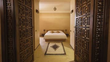 Um quarto com cama, tapete e um painel decorativo na parede.