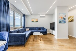 Apartamento Deluxe, vista para o mar | Sala de estar | TV de ecrã plano