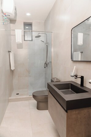 Apartamento básico, vista para a cidade | Banheiro | Chuveiro, toalhas de banho, sabonete, papel higiênico