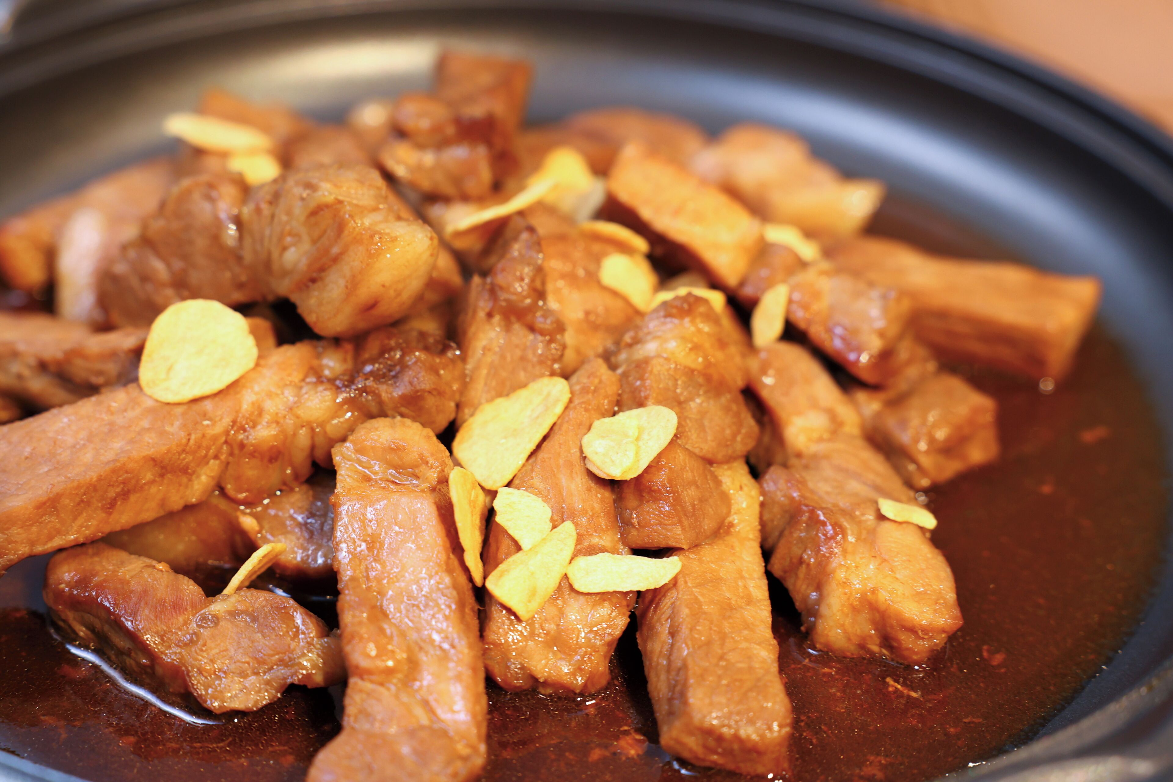 Um close-up de um prato com carne e amêndoas fatiadas.